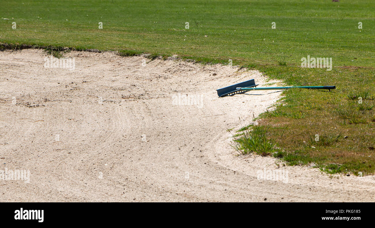 view of sand rake lying in a bunker on a golf course Stock Photo - Alamy