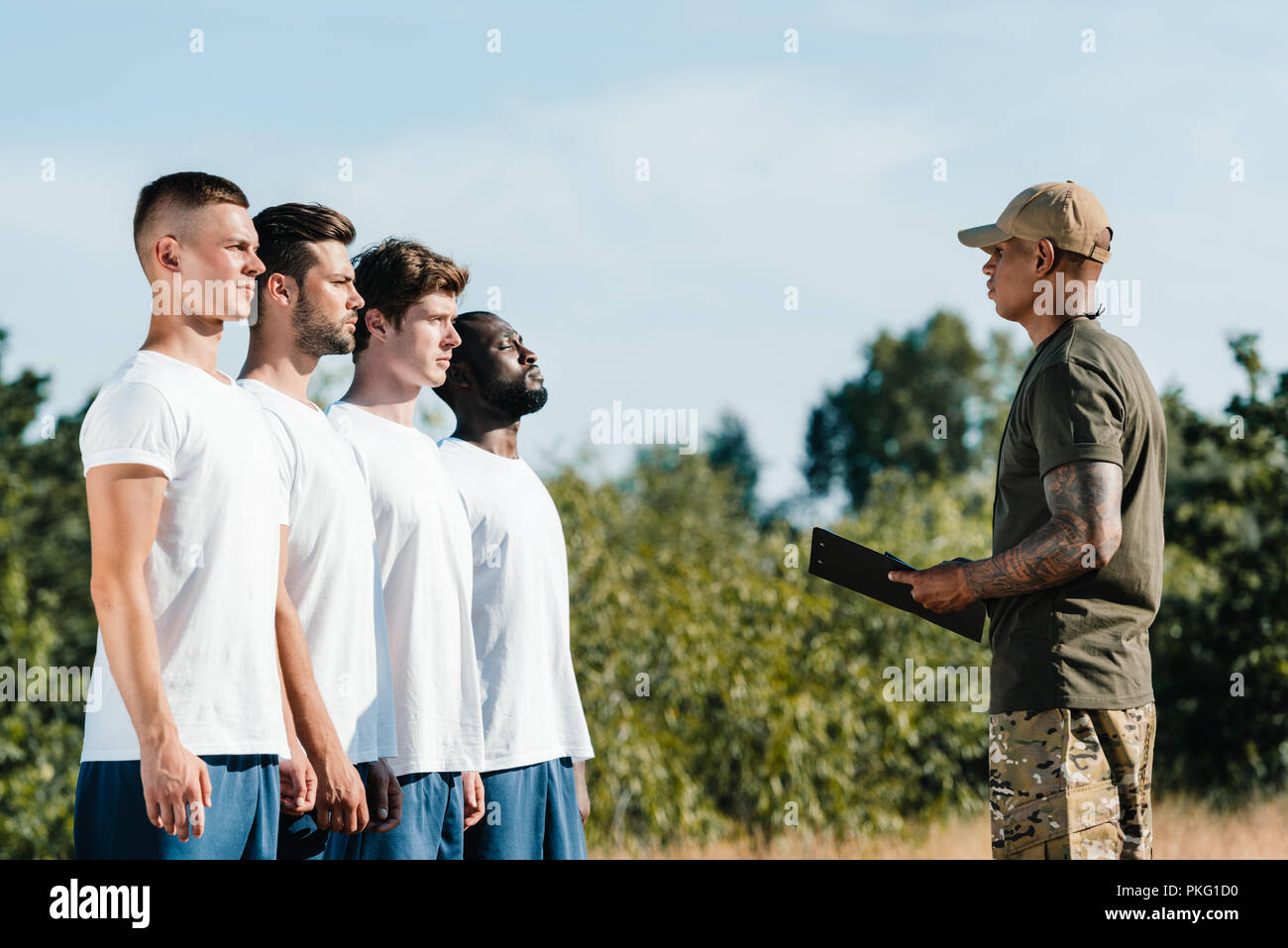 side view of african american tactical instructor with notepad and ...