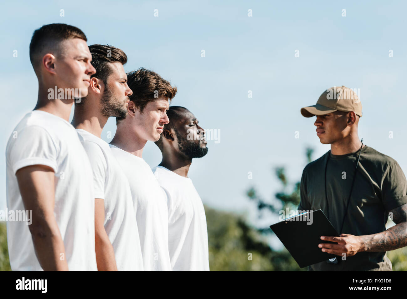 side view of african american tactical instructor with notepad and ...