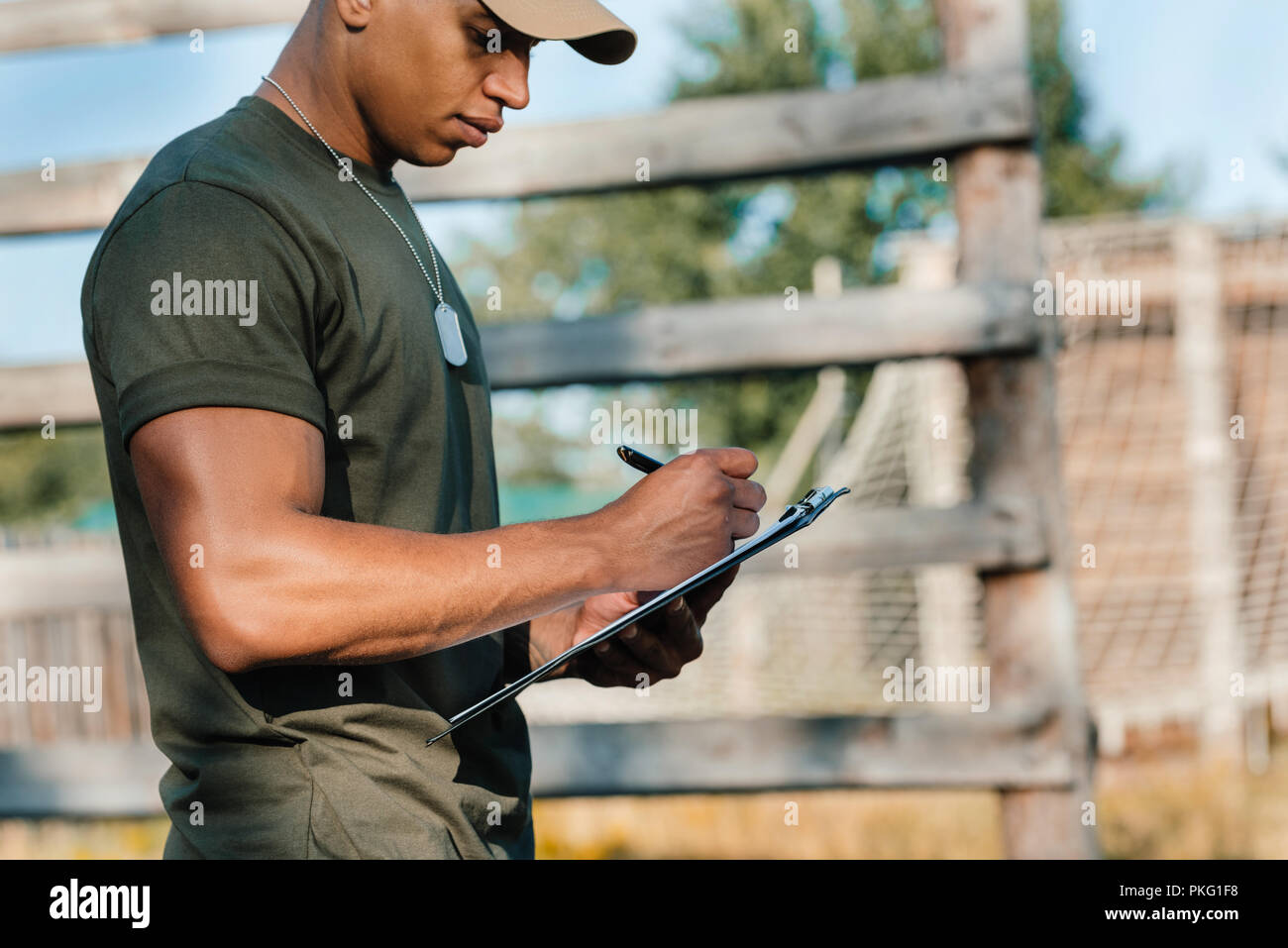 side view of african american tactical instructor making notes in ...