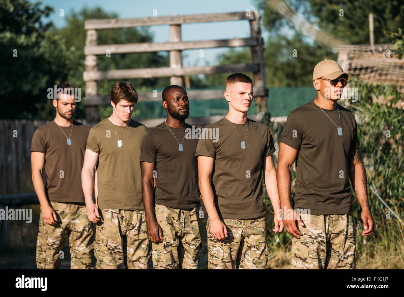 multiethnic group of young soldiers in military uniform with tag dogs ...