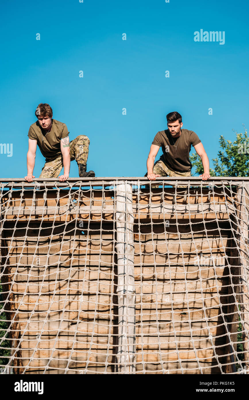 low angle view of young soldiers practicing during obstacle run on ...