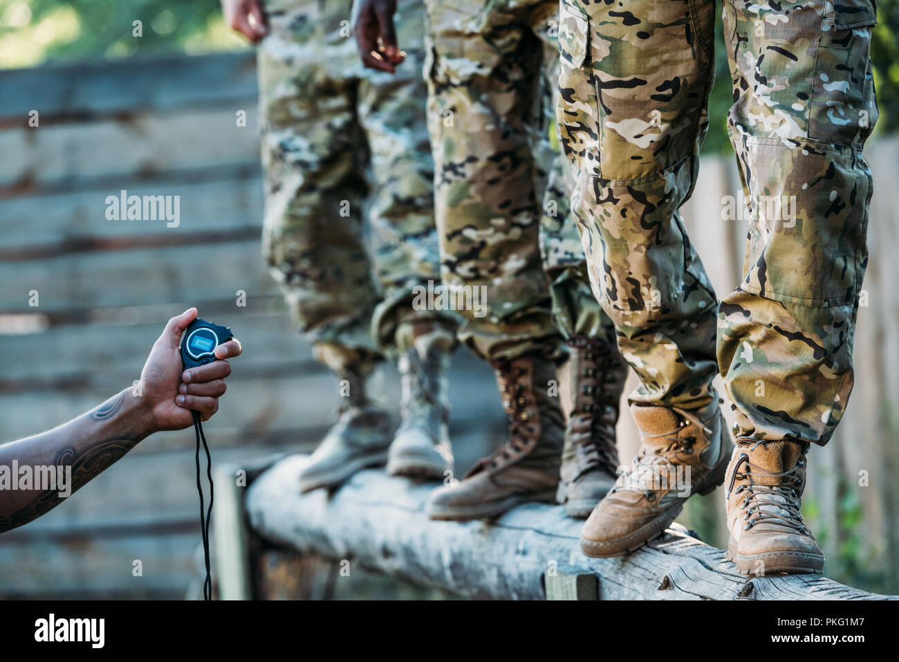 partial view of tactical instructor with stop watch examining ...