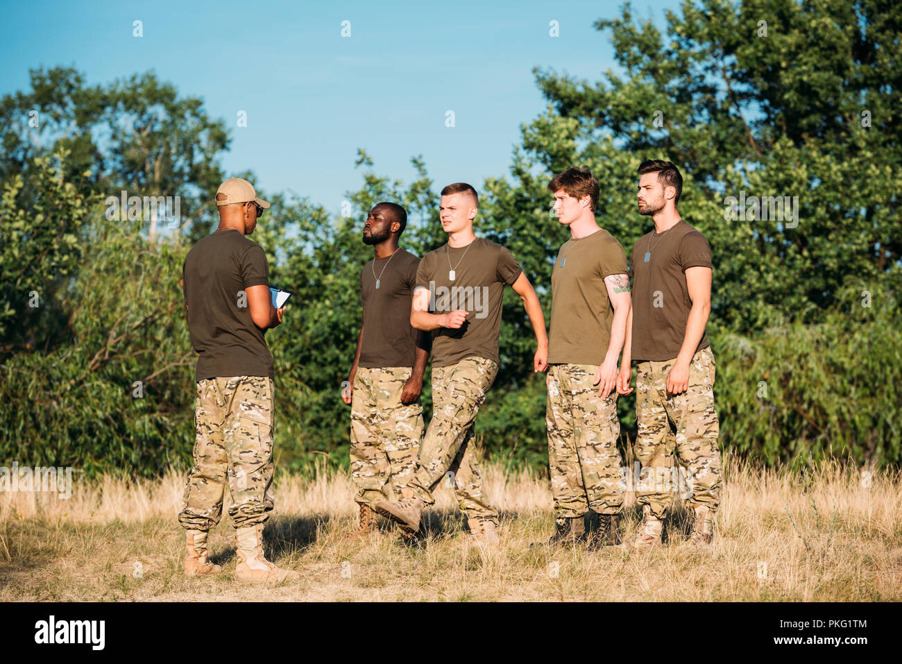african american tactical instructor with notepad and young multiethnic ...