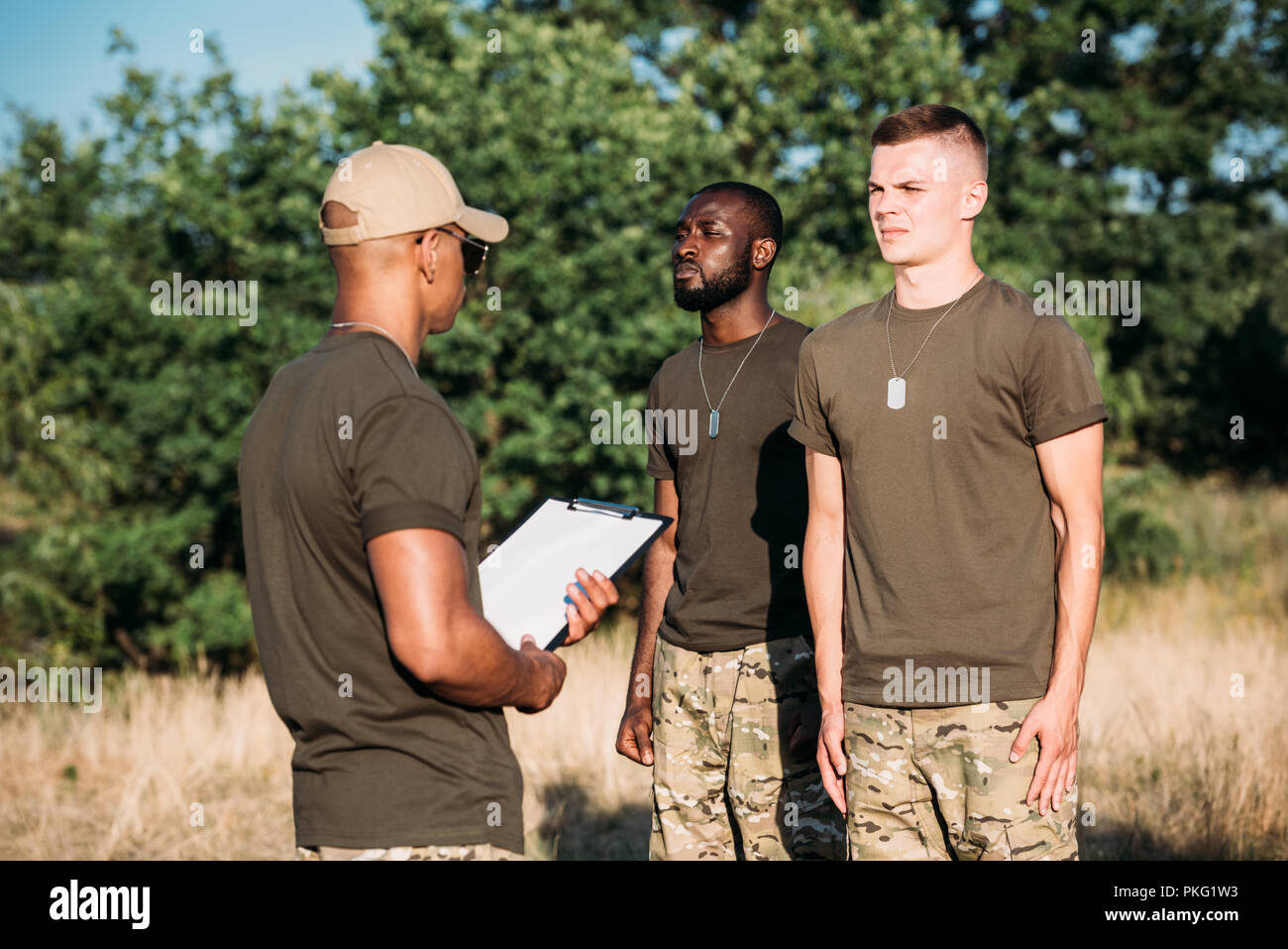 african american tactical instructor with notepad and young multiracial ...