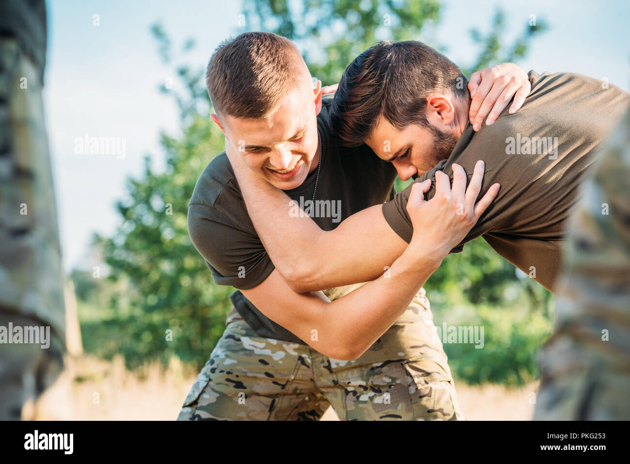 selective focus of young soldiers practicing hand to hand fighting on ...