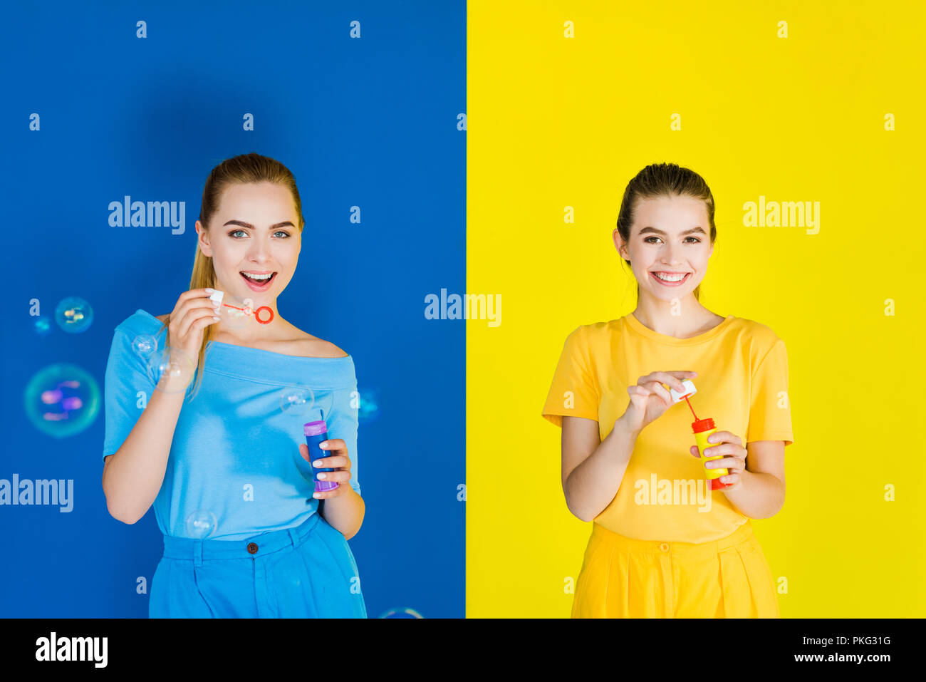 Female fashion model having fun blowing bubbles on blue and yellow ...