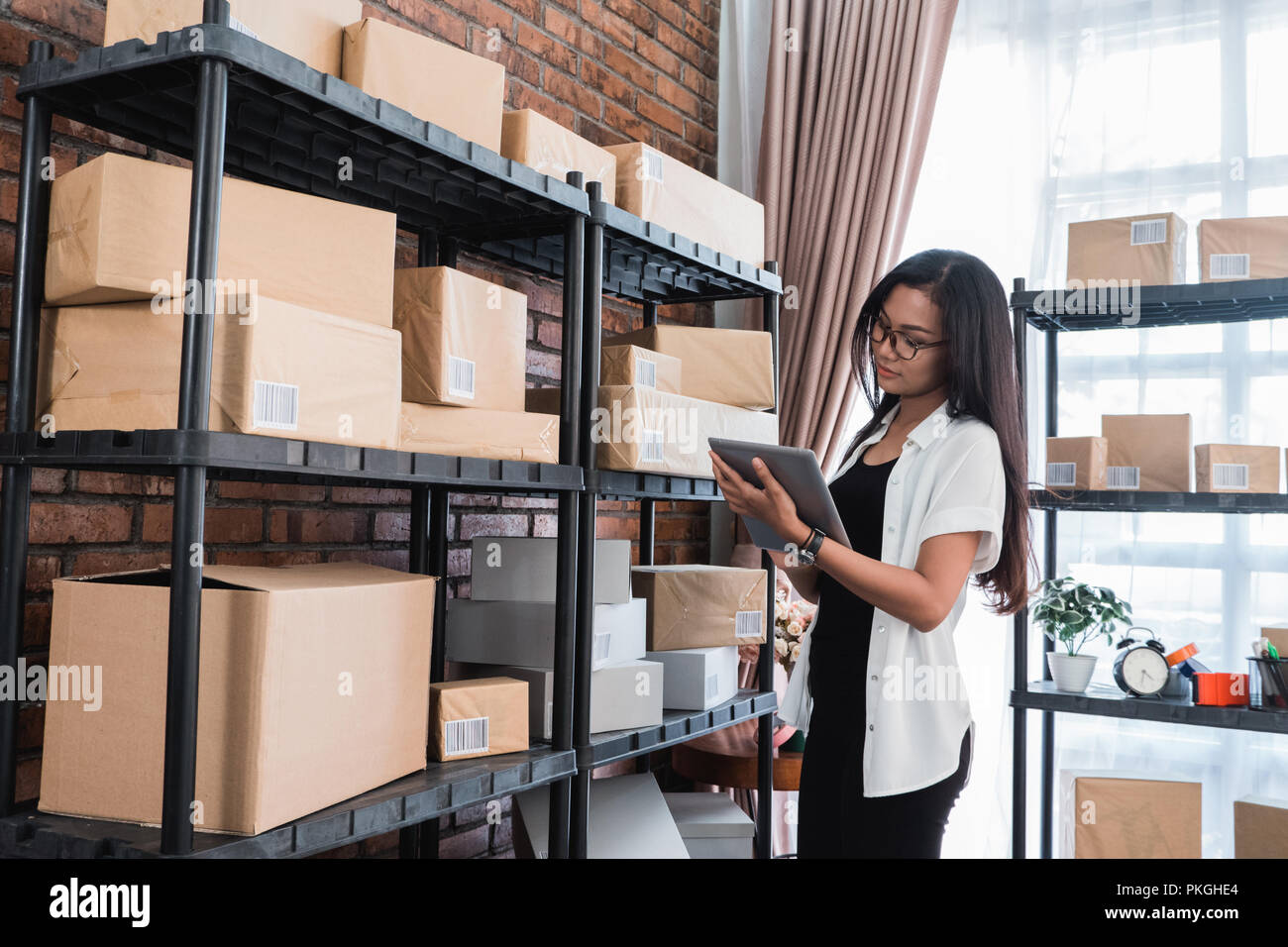 asian woman with tablet counting package Stock Photo - Alamy