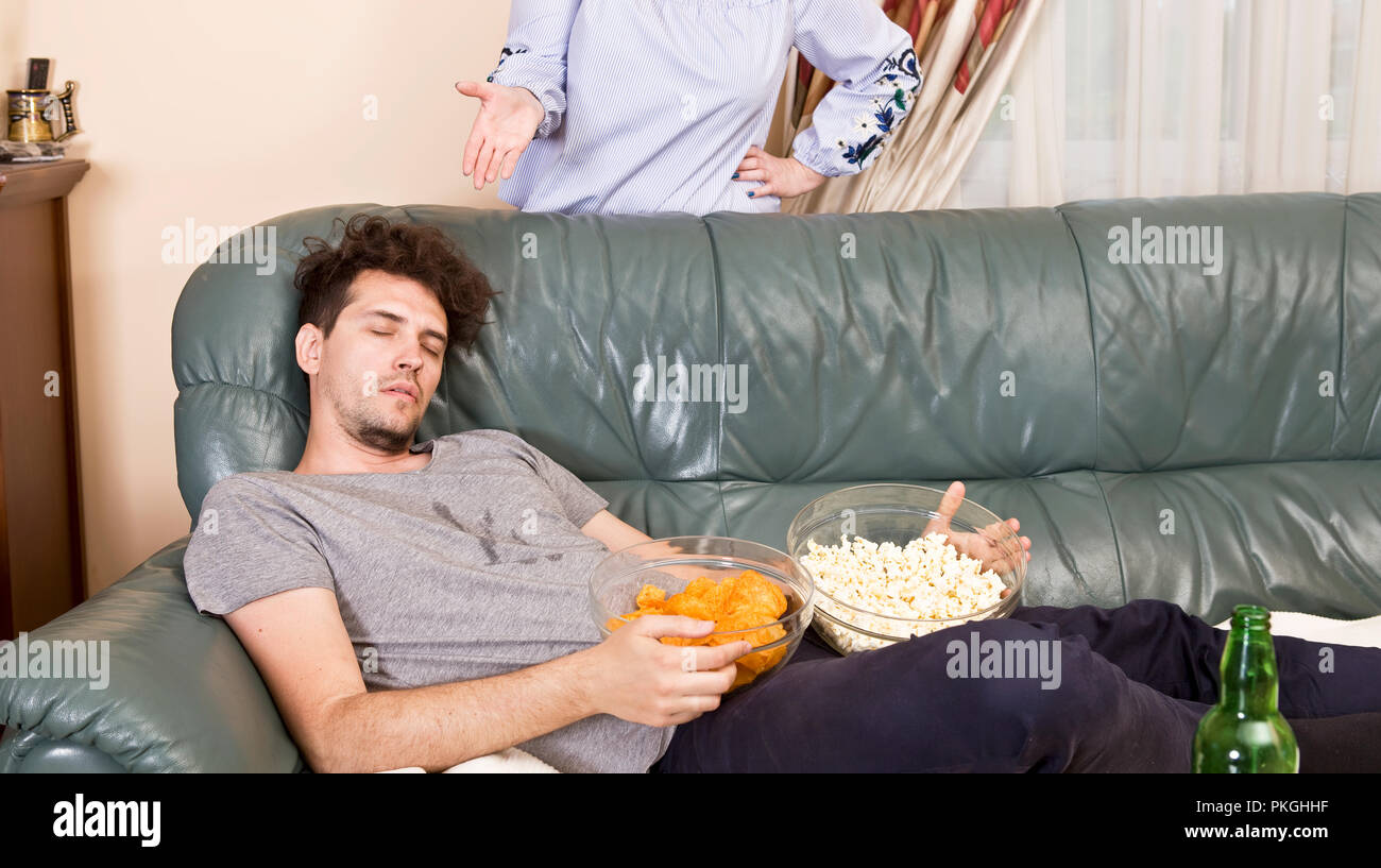 Man after heavy partying at home. Angry wife Stock Photo - Alamy