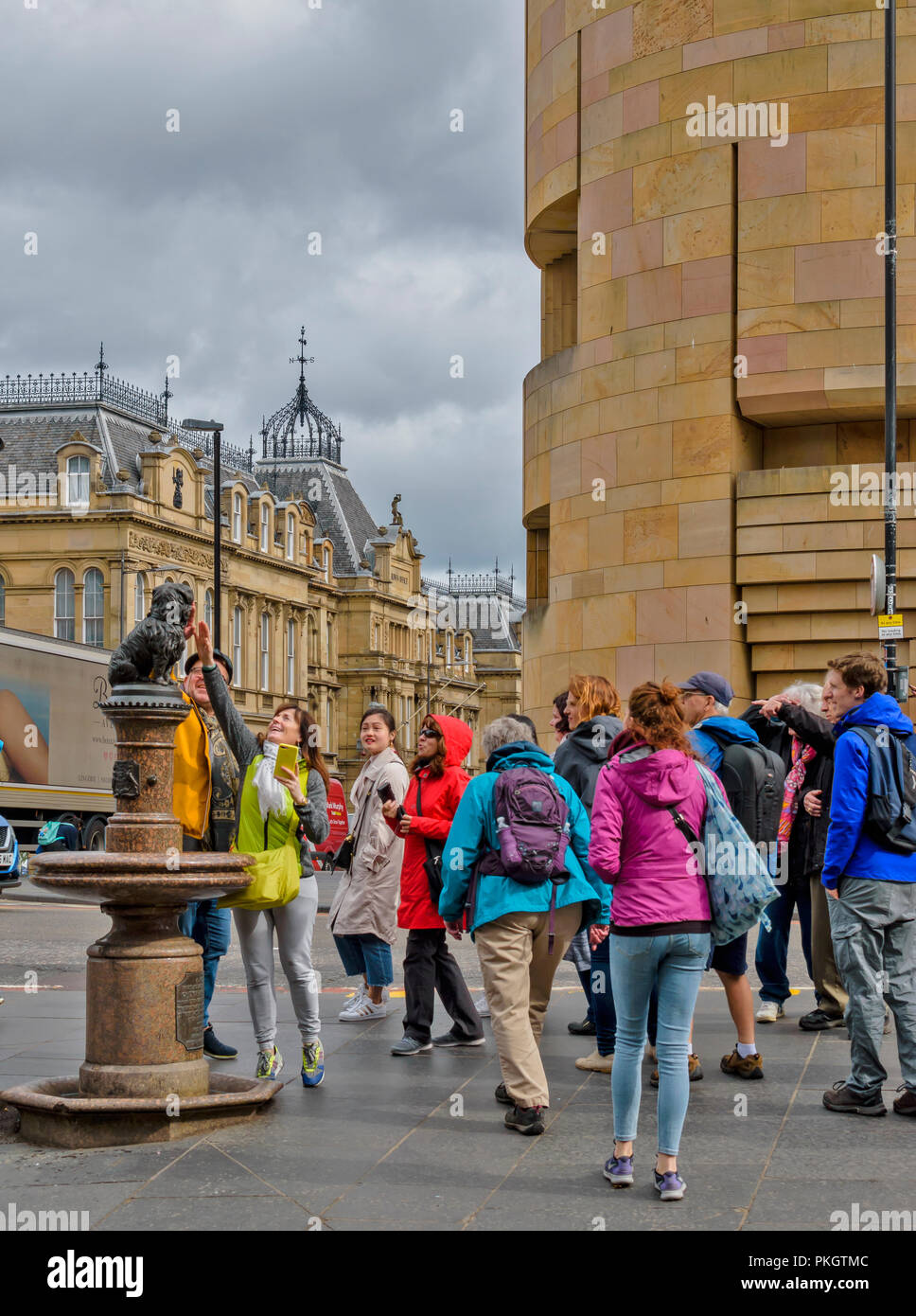 EDINBURGH SCOTLAND TOURISTS REACHING UP TO TOUCH THE NOSE OF GREYFRIARS ...