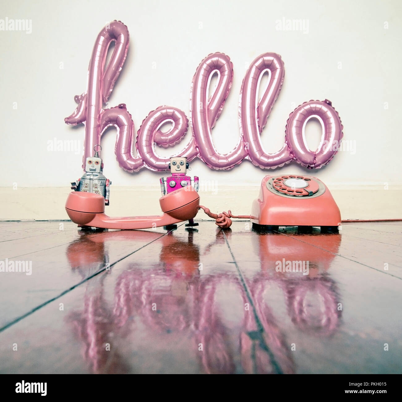 a pink hello balloon and two robots on the phone with reflection bright ...
