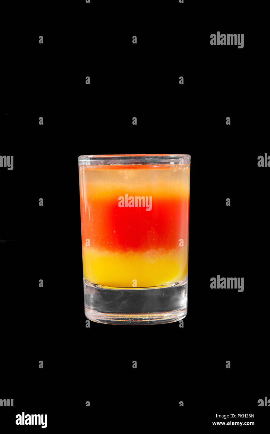 Multicolored layered cocktail, glass with transparent and colored drink ...