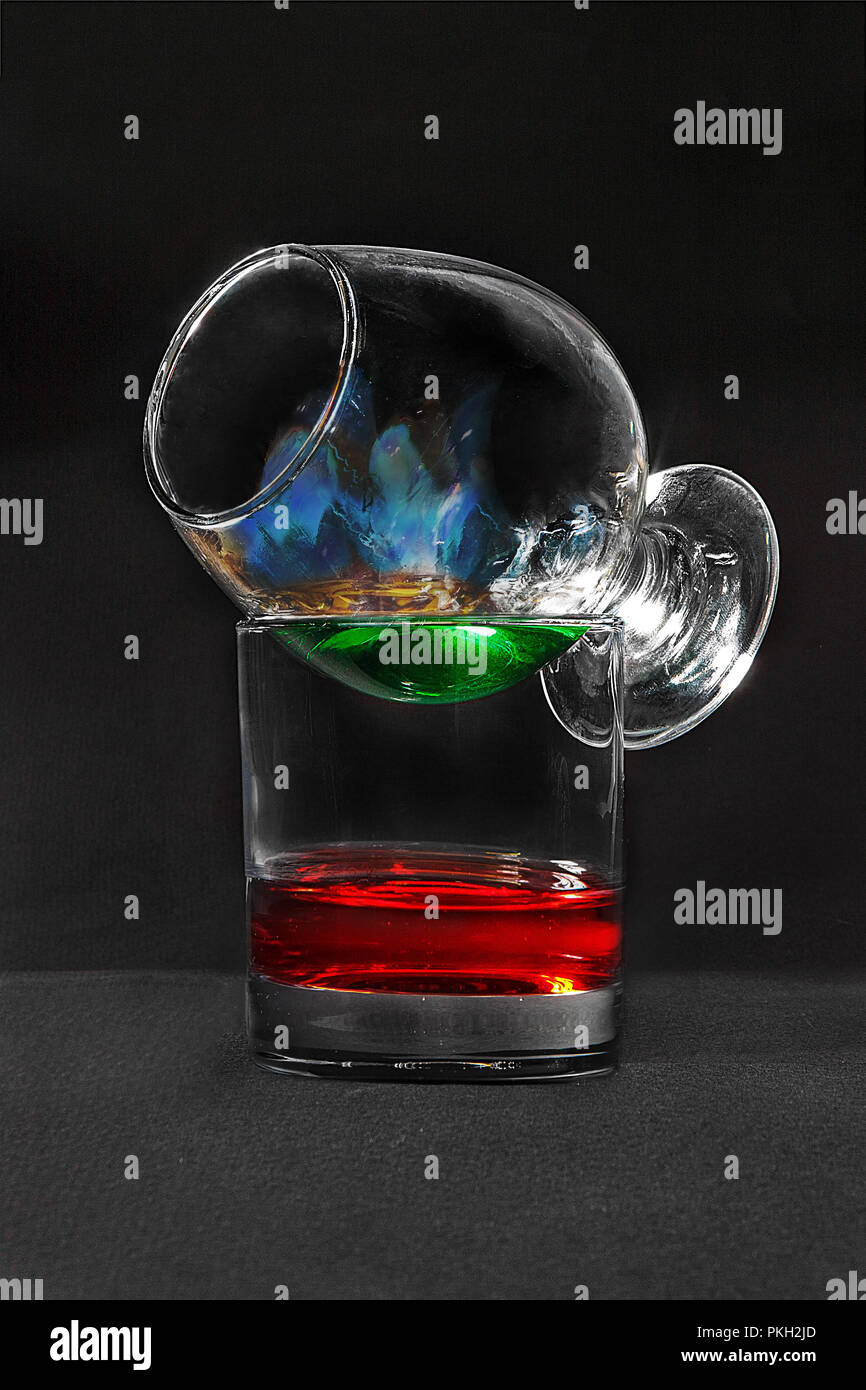 A cocktail burning with blue flame with absinthe and tonic, syrup, a ...