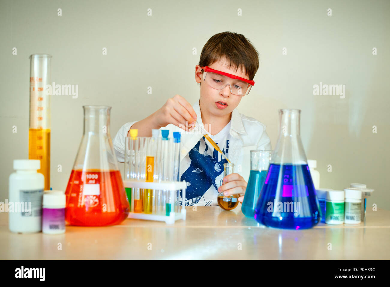 Cute boy is making science experiments in a laboratory Stock Photo - Alamy