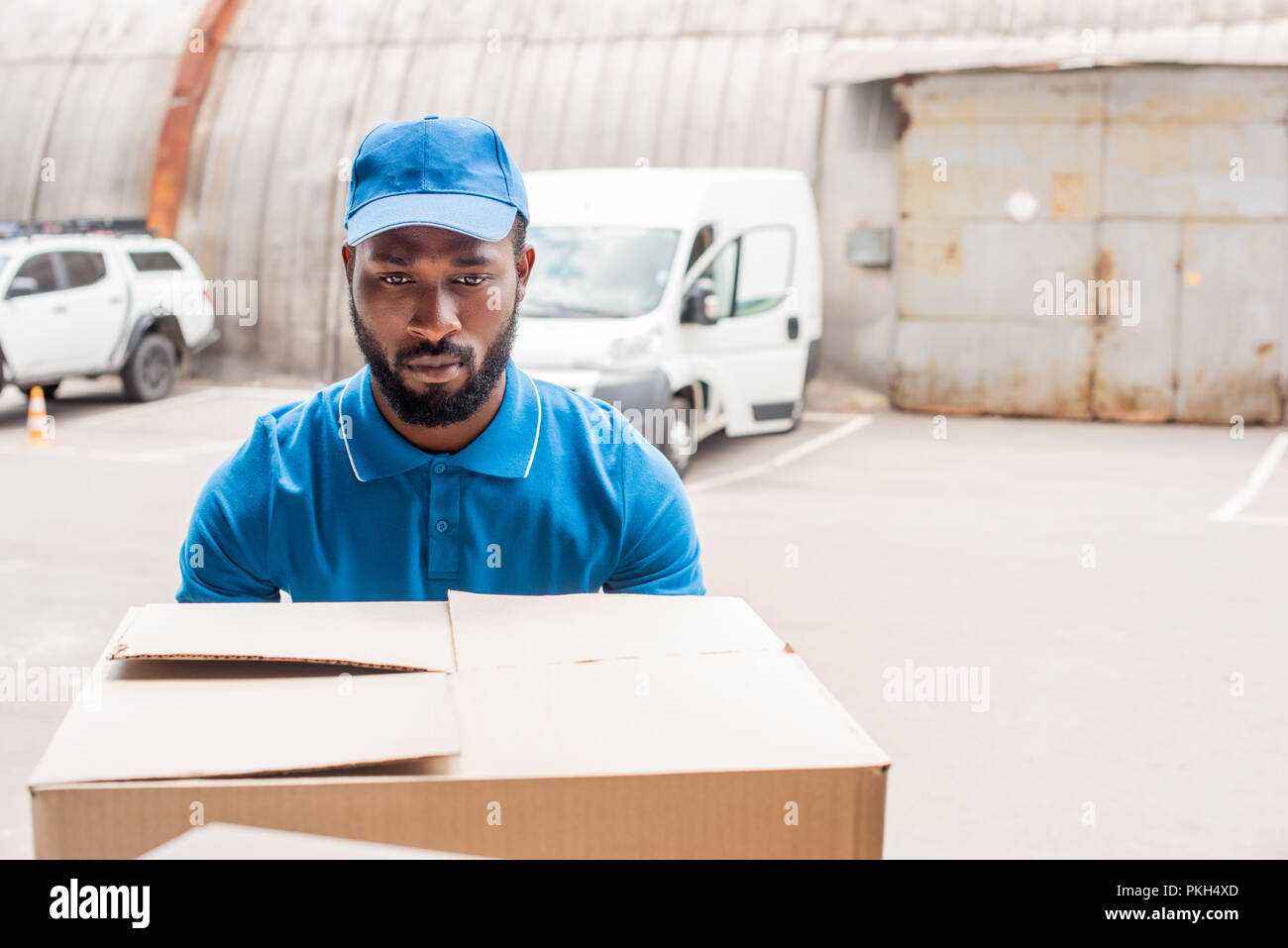 african american courier carrying big box Stock Photo - Alamy