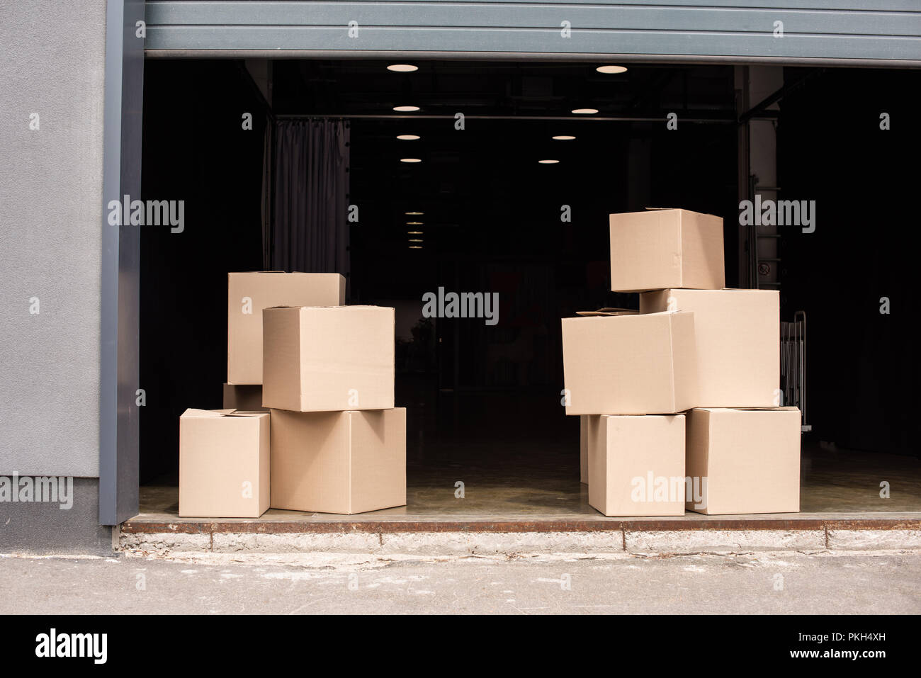 cardboard boxes on each other near open garage Stock Photo - Alamy