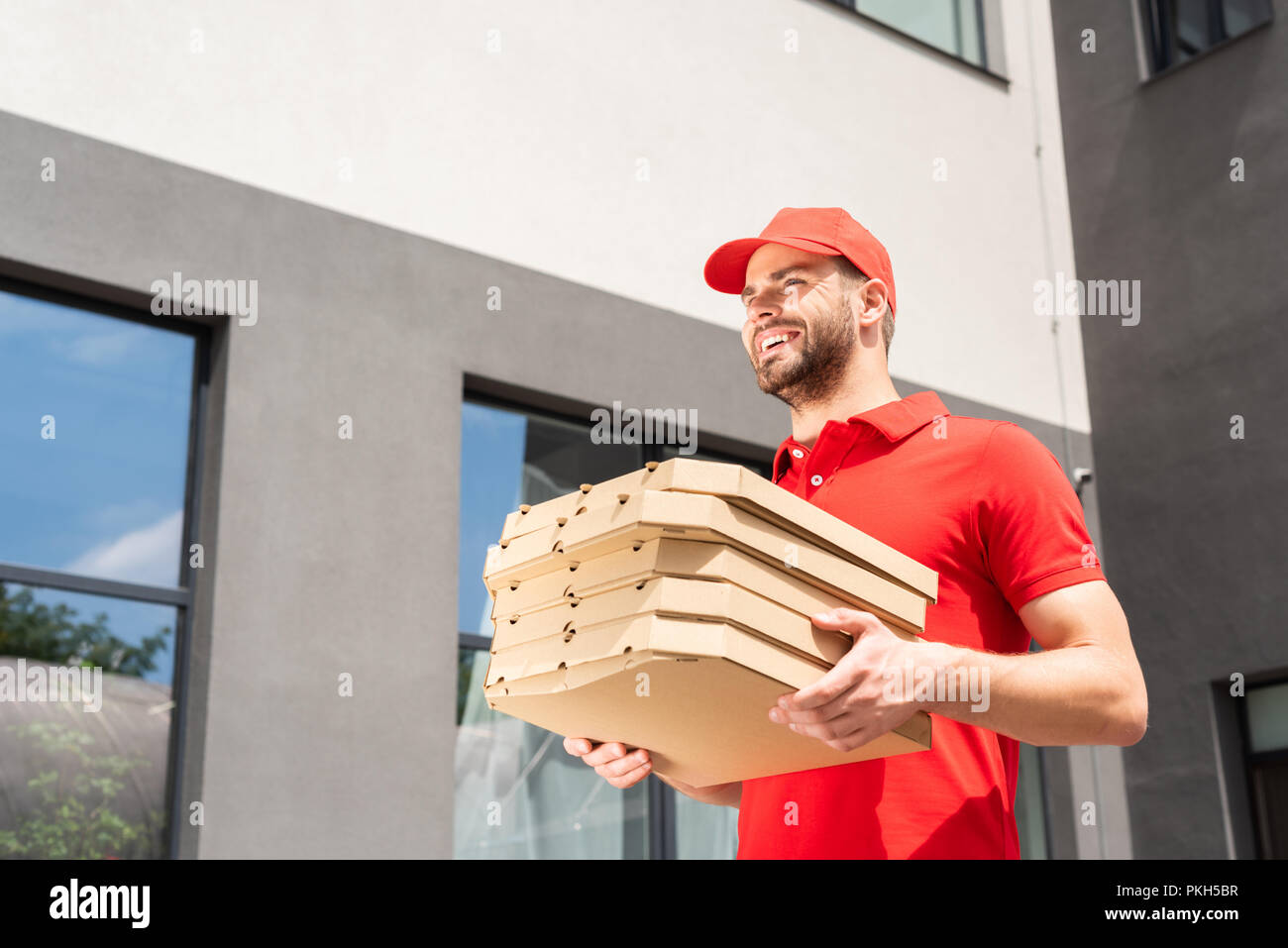 low angle view of caucasian delivery man carrying pizza boxes Stock ...