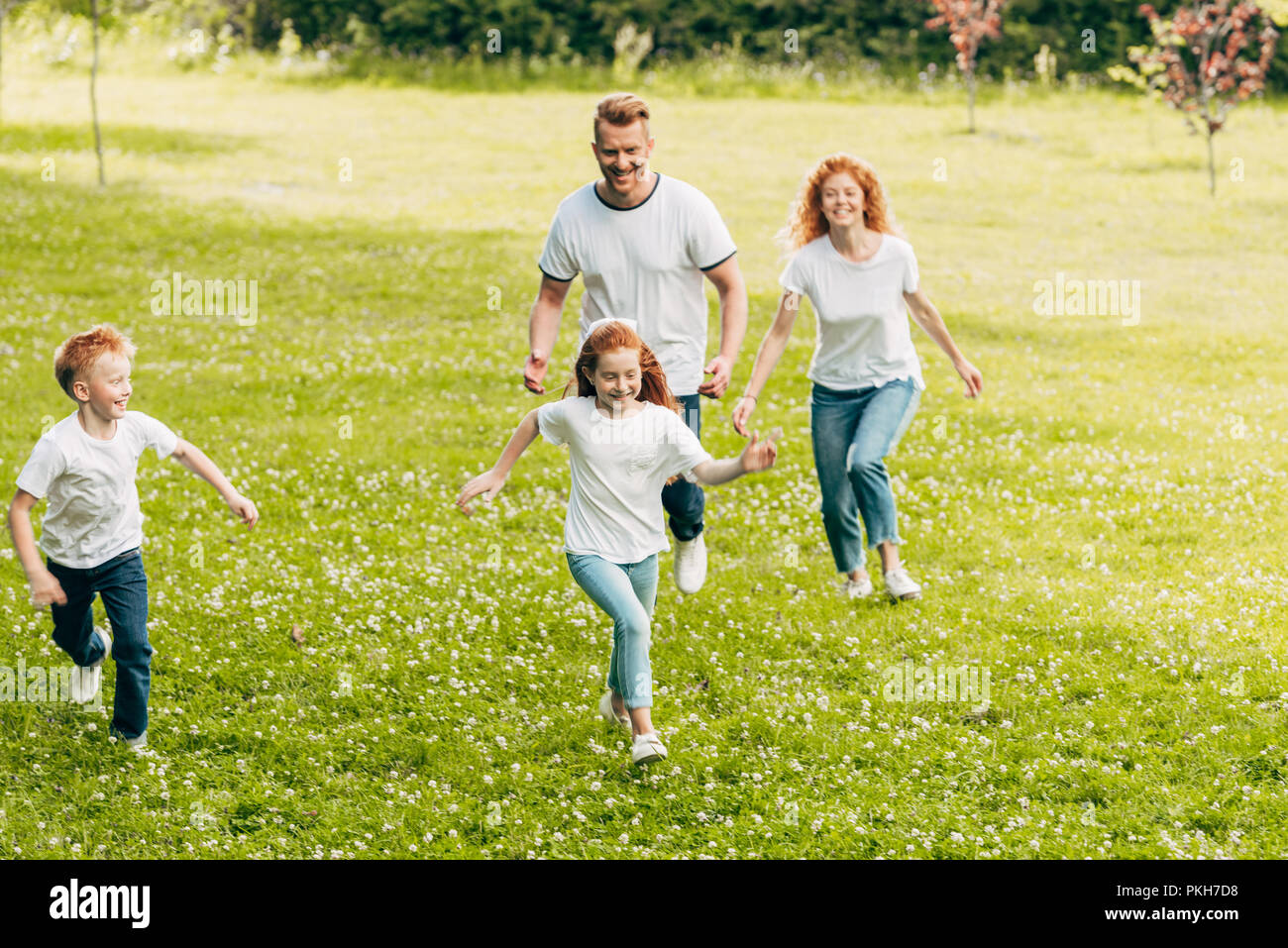 happy family with two kids having fun and running together at park ...