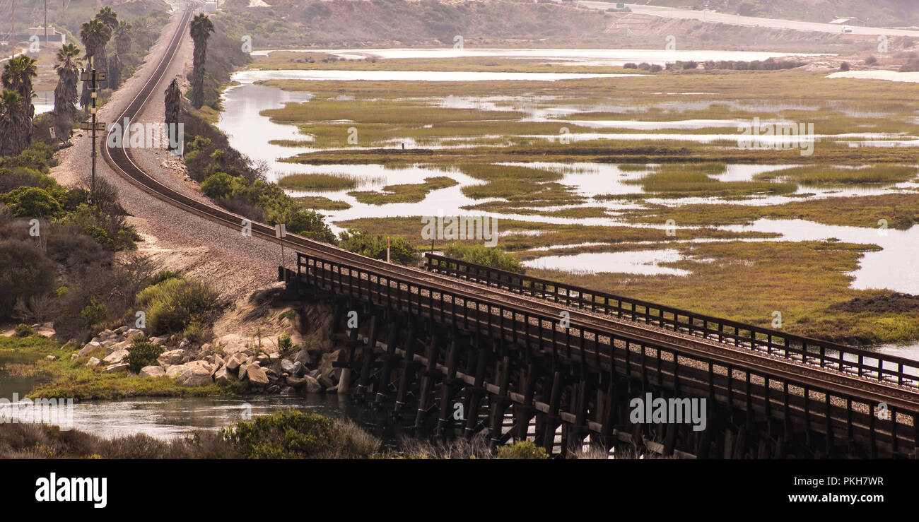 Railroad track runs through a bridge and water Stock Photo - Alamy