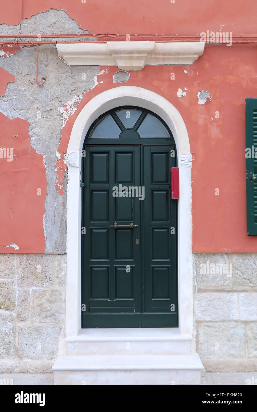Retro door with arch detail on top and ruined scratched facade wall ...