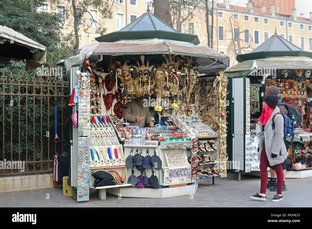 Tourists looking at arts and crafts sold in small kiosk selling ...
