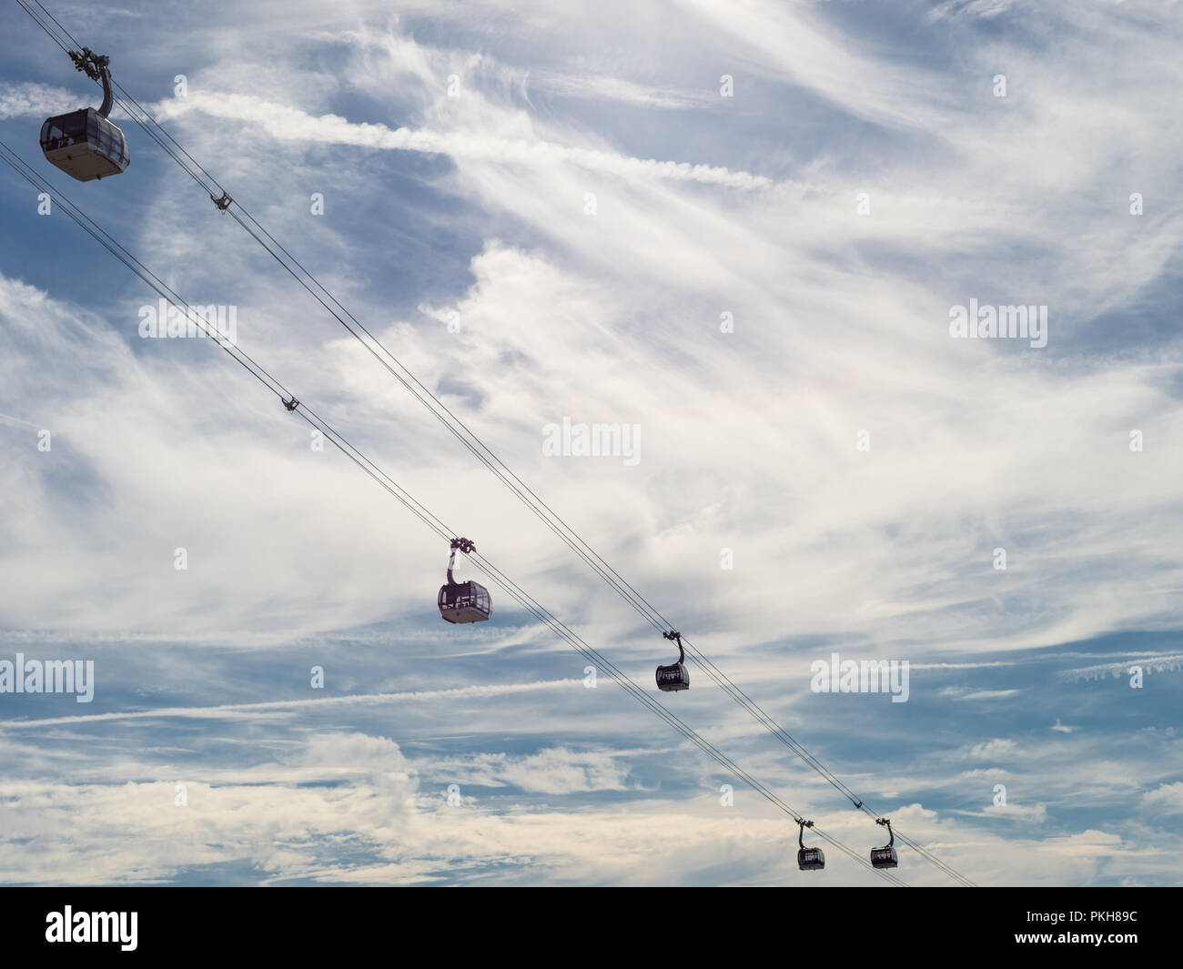 Ropeway with wagons on a background of blue sky with clouds Stock Photo ...