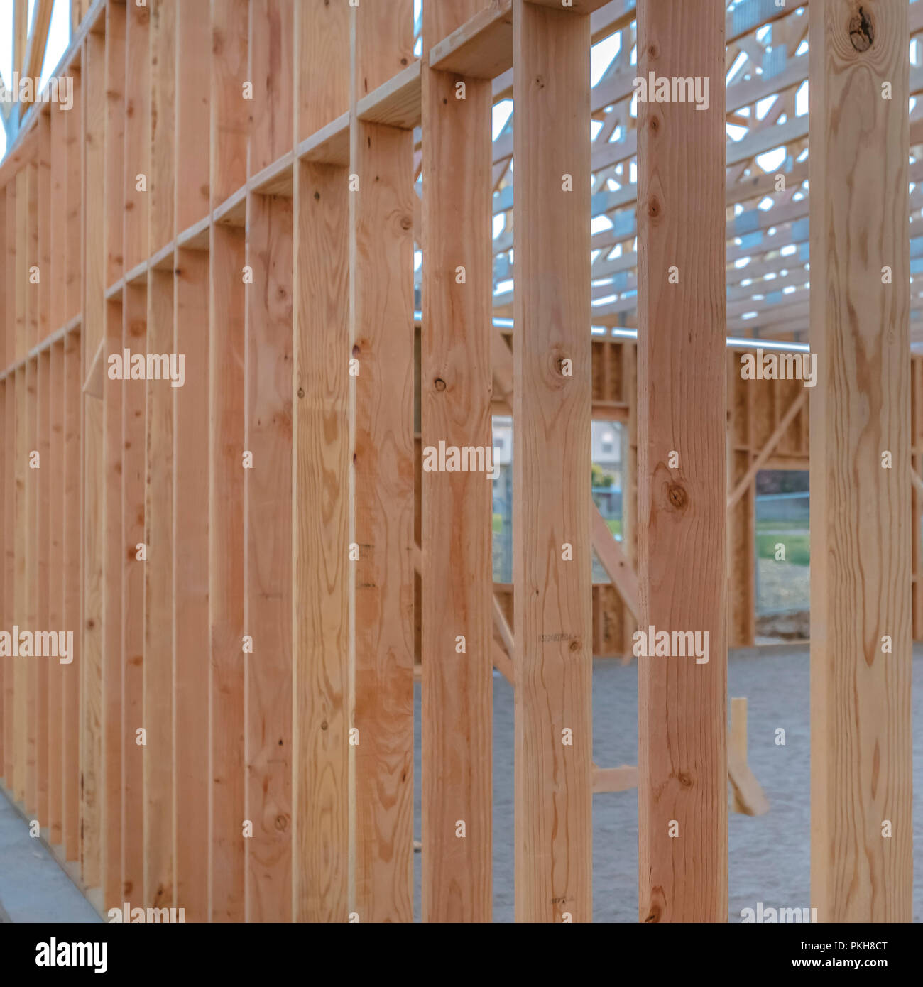 Some vertical wooden beams sandy ground square Stock Photo - Alamy