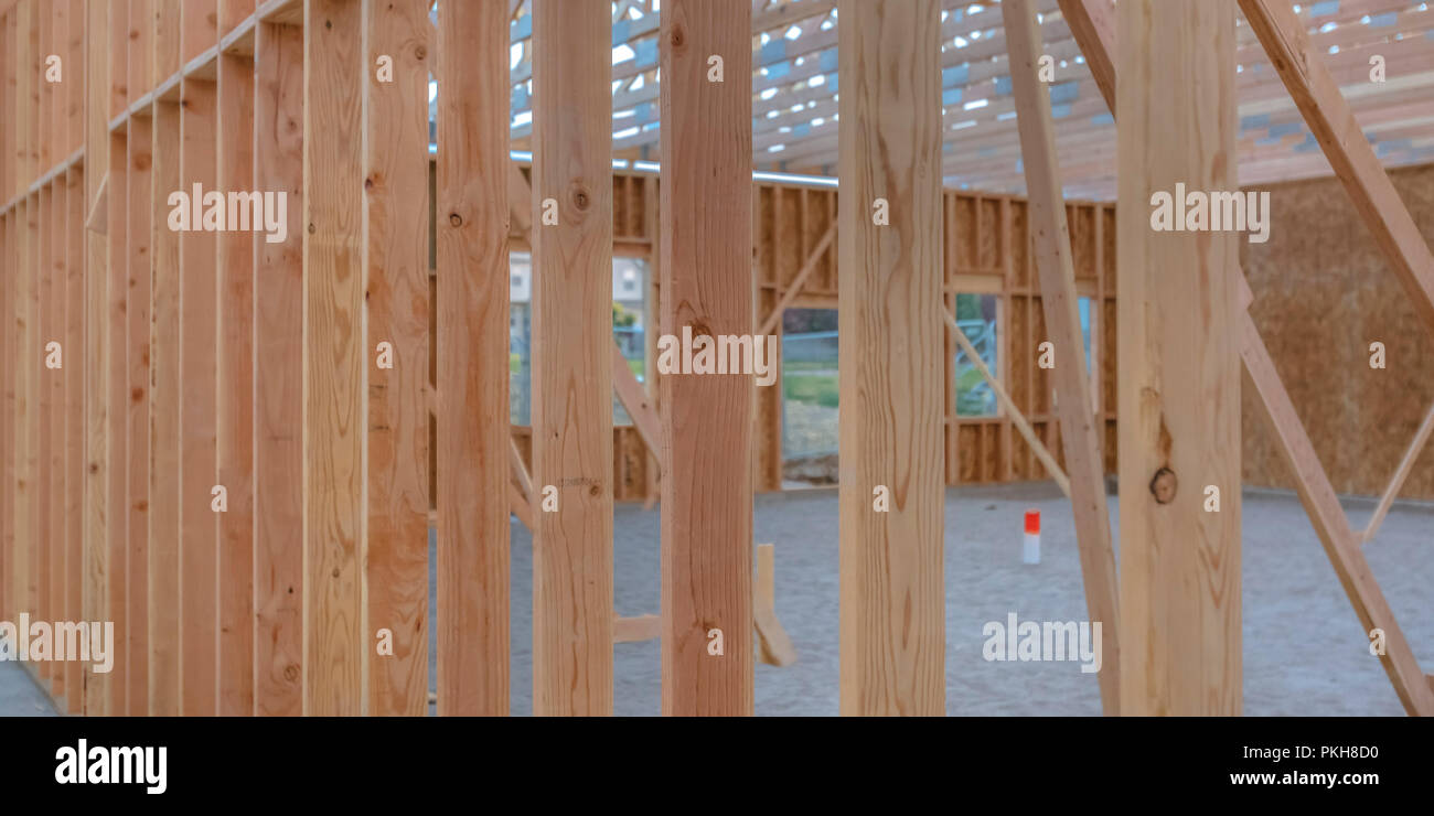Some vertical wooden beams with sandy ground wide Stock Photo - Alamy