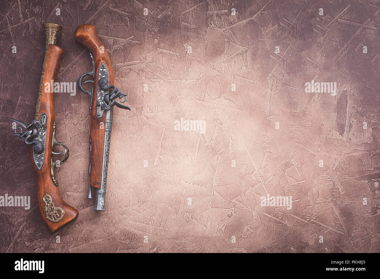 Two vintage pistols on wooden background, toned Stock Photo - Alamy