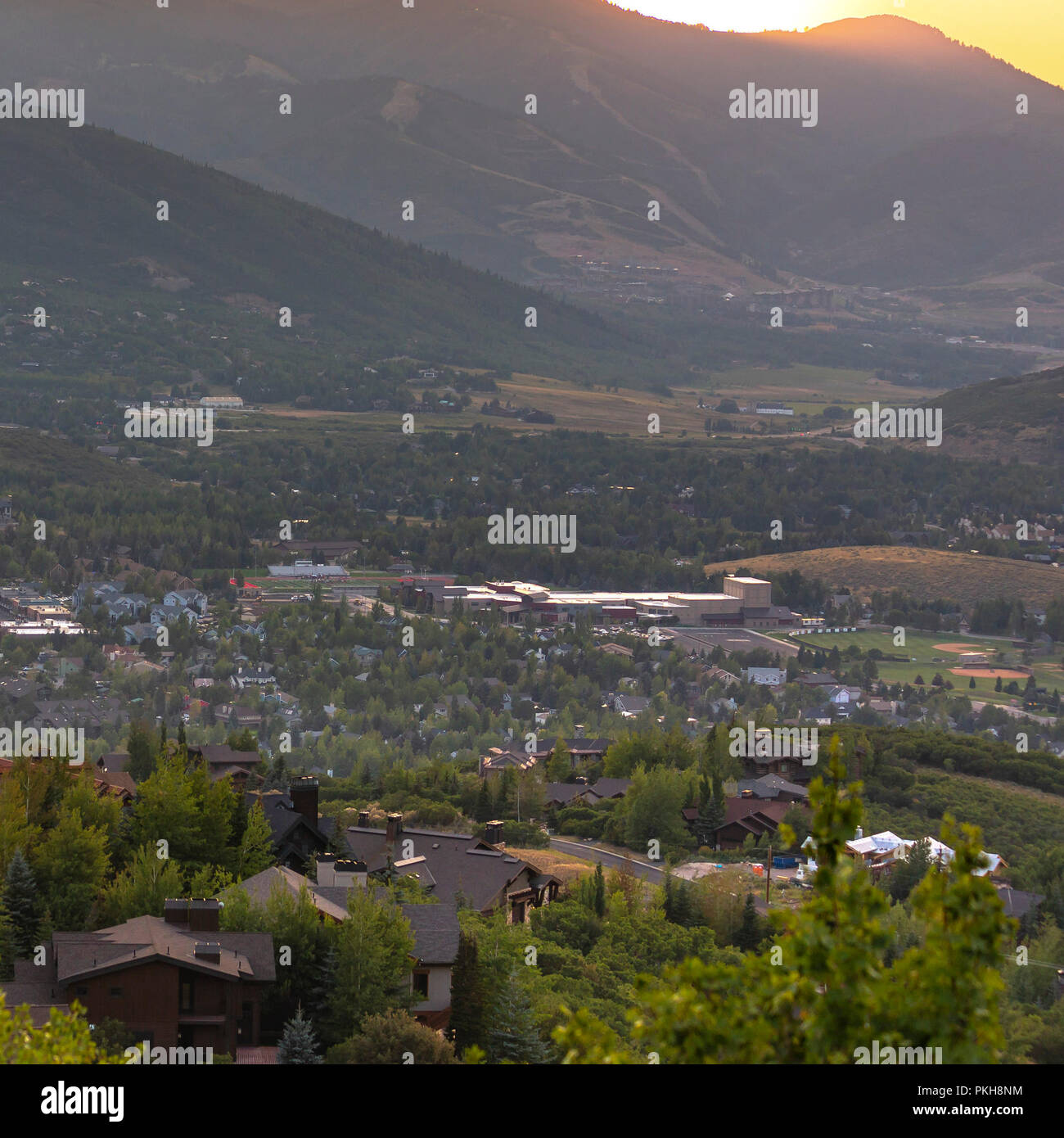 Sunset behind mountains with homes in front Stock Photo - Alamy