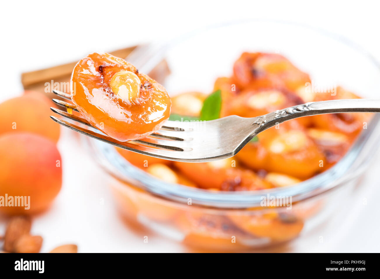 Caramelized apricots with almonds isolated on white Stock Photo - Alamy