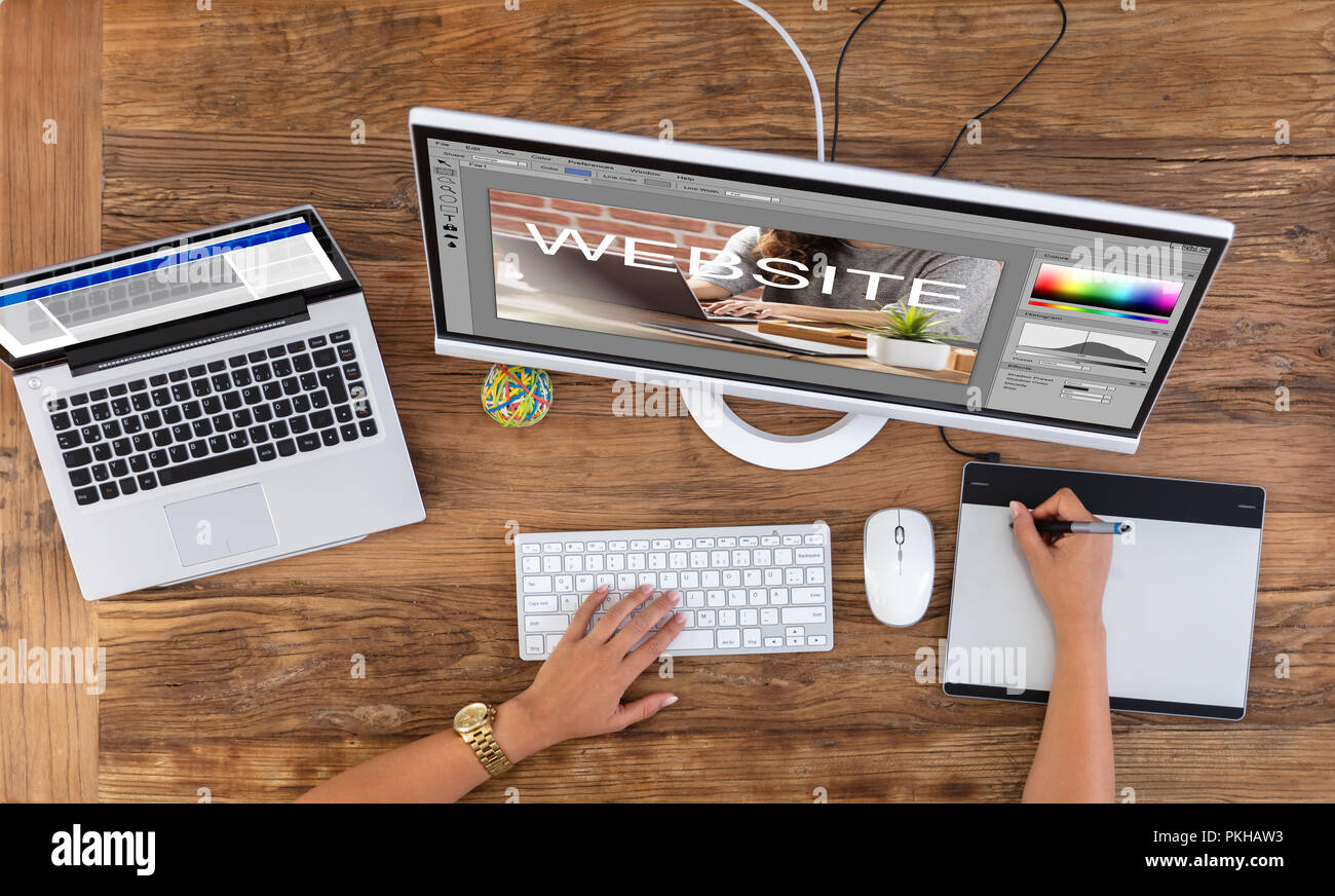 Female Designer's Hand Using Graphic Tablet While Creating Website On ...