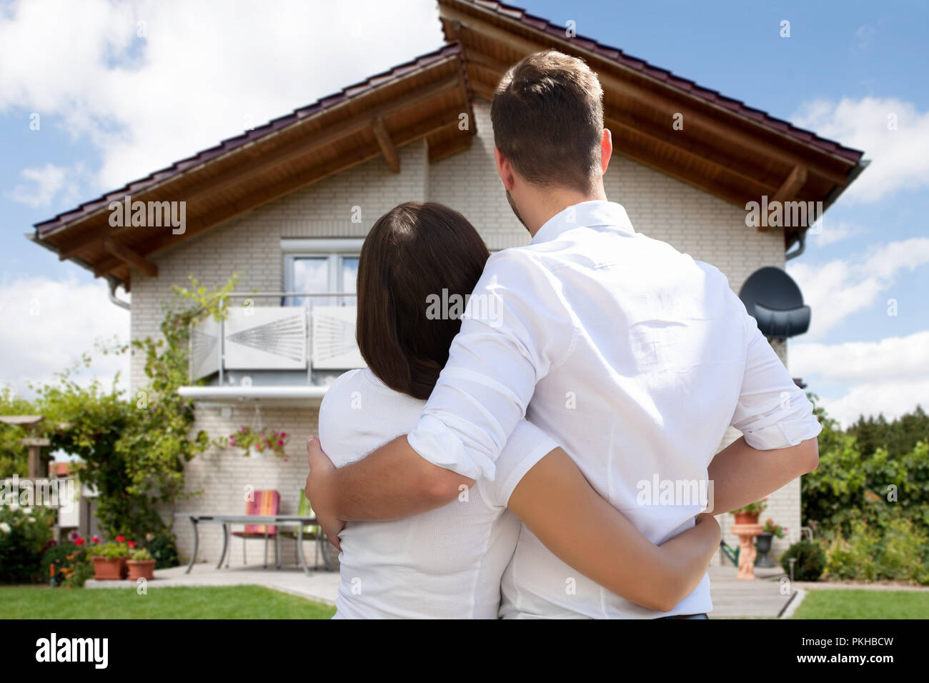 Rear View Of A Young Couple Standing In Front Of Their New House Stock ...
