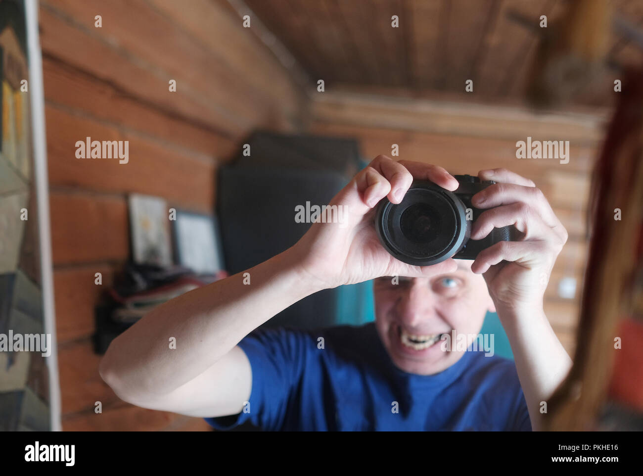 Male photographer pointing a camera above his head with grimace on a ...
