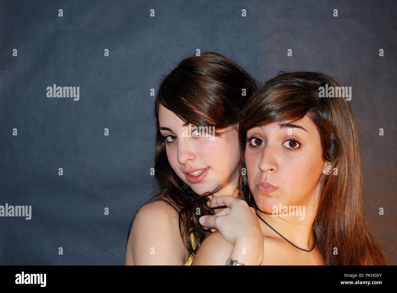 Two young women looking at the camera and making gestures Stock Photo ...