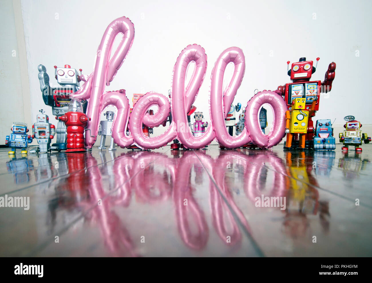 robots holding up the word hello on a old wooden floor with reflection ...