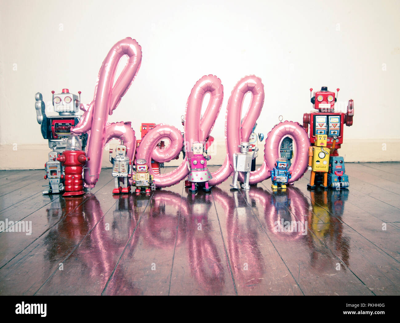 robots holding up the word hello on a old wooden floor with reflection ...