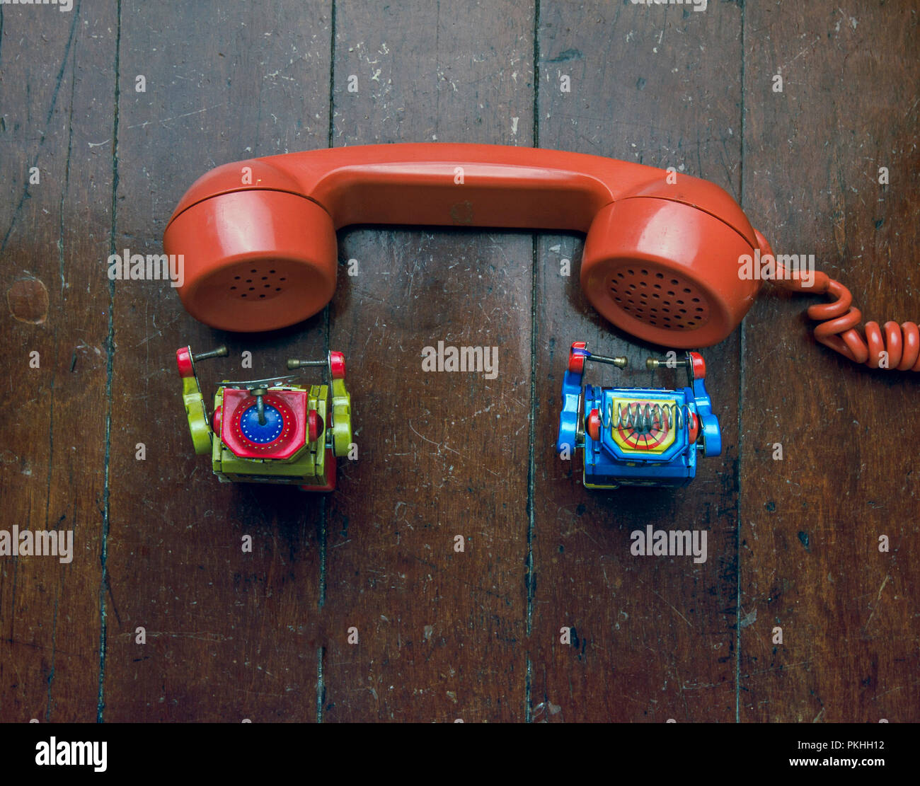 two little retro robots on the phone on a old wooden floor shot from ...