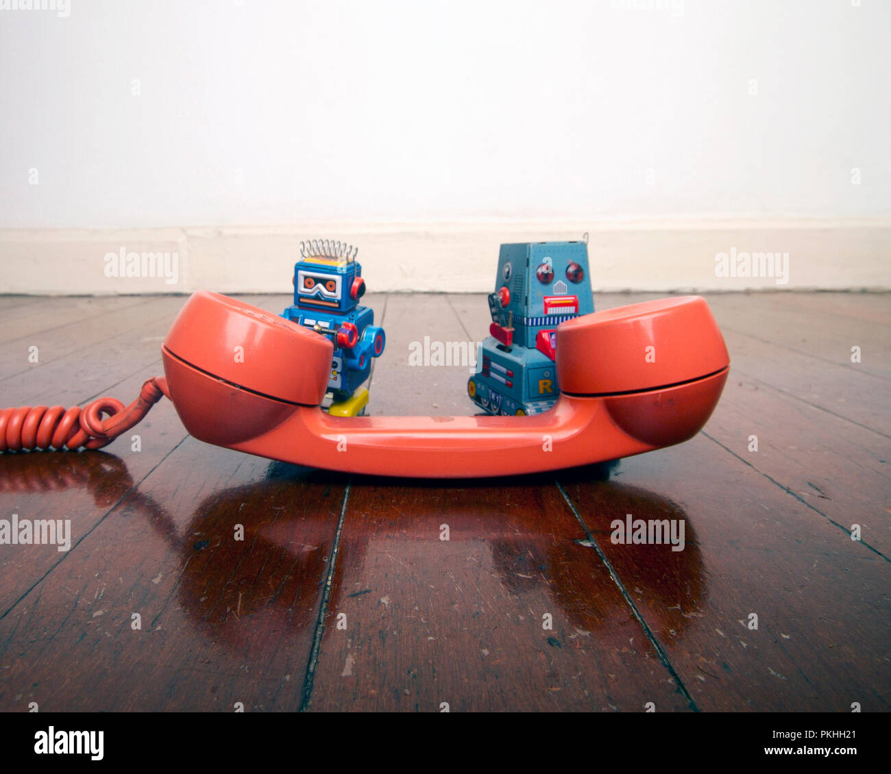 two little retro robots on the phone on a old wooden floor with copy ...