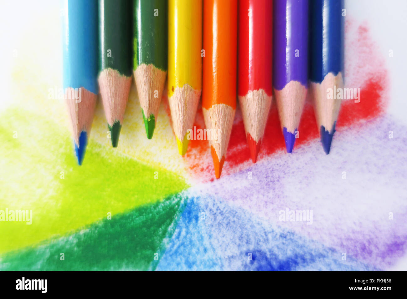 A row of primary colored colored pencils on a color wheel on a white ...