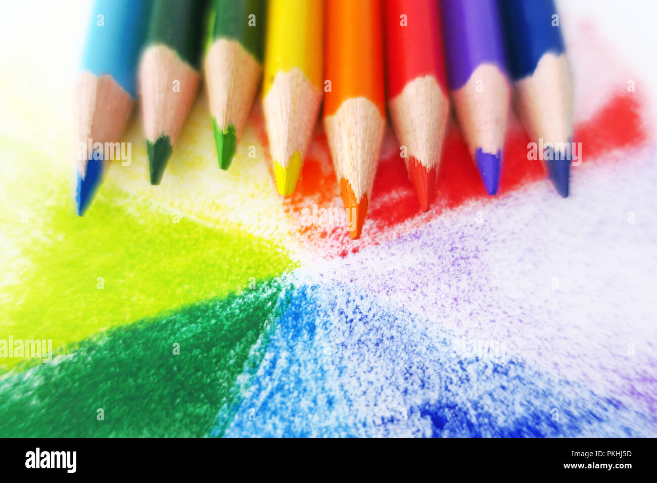 A row of primary colored colored pencils on a color wheel on a white ...