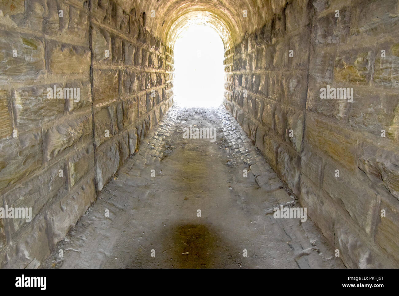 A light in the end of a tunnel. Passage under the railway Stock Photo ...