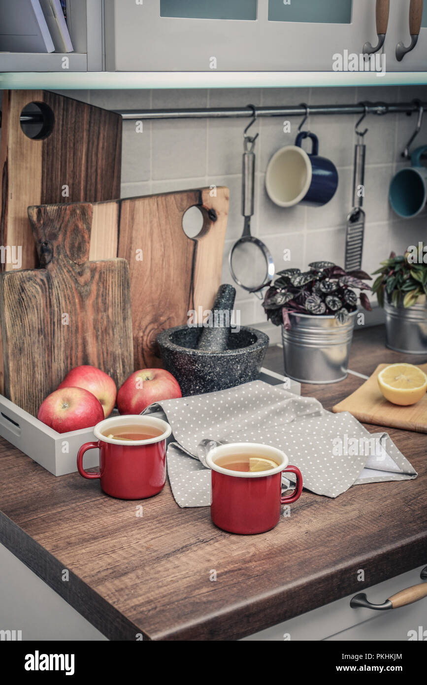 Interior of a modern domestic kitchen with metal cups of tea and lemon ...