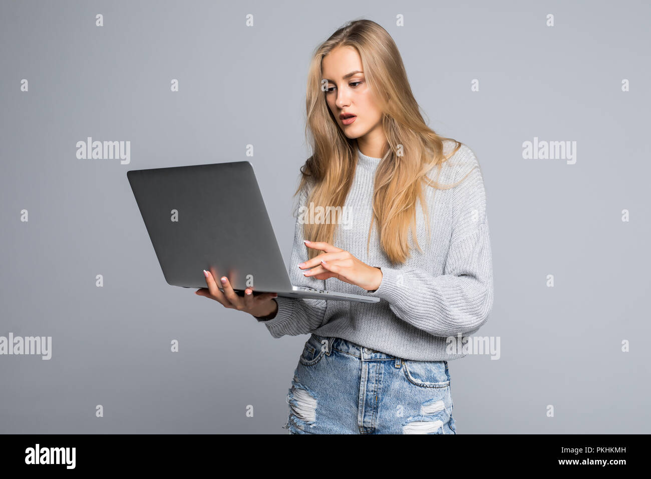 Young happy smiling woman in casual clothes holding laptop and sending ...