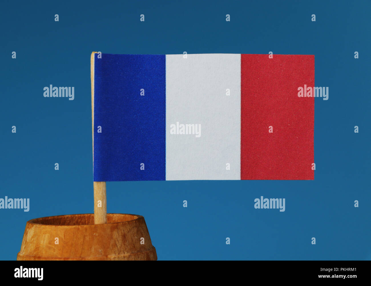 A national flag of France on wooden stick in wooden barrel. Blue ...