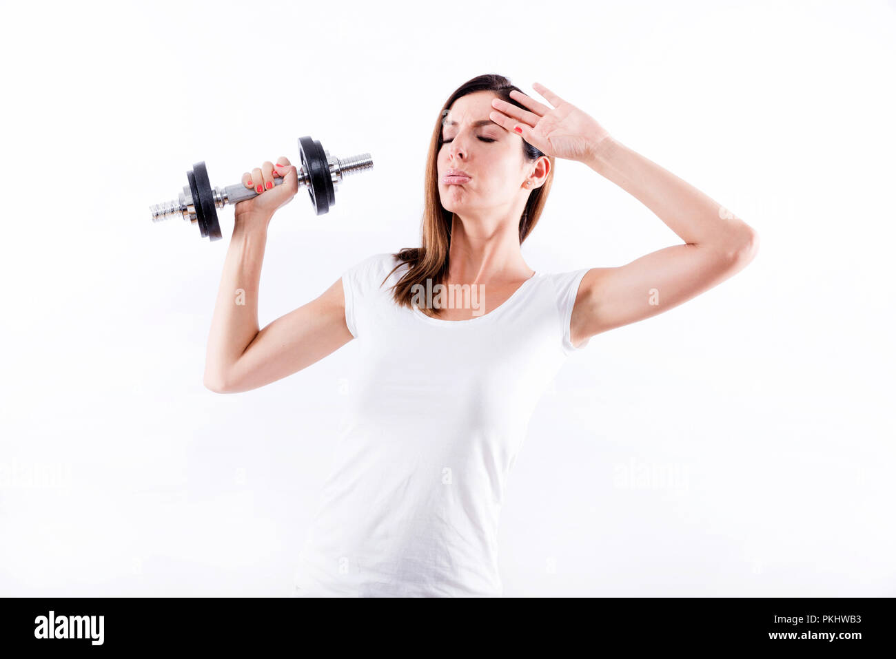 A beautiful young woman lifting weight and feeling exhausted Stock ...
