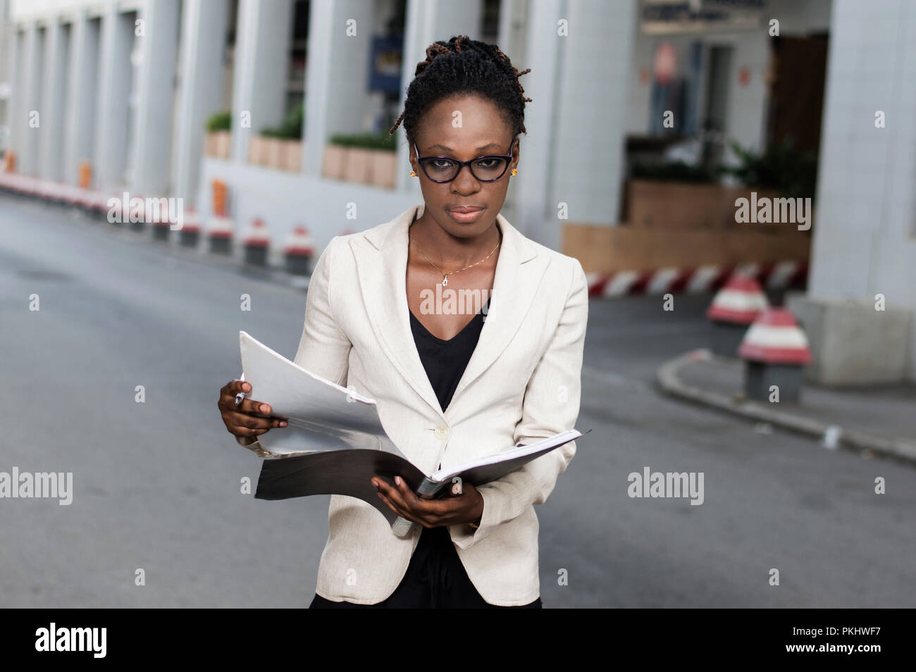 Beautiful young business woman holding a folder containing sales ...