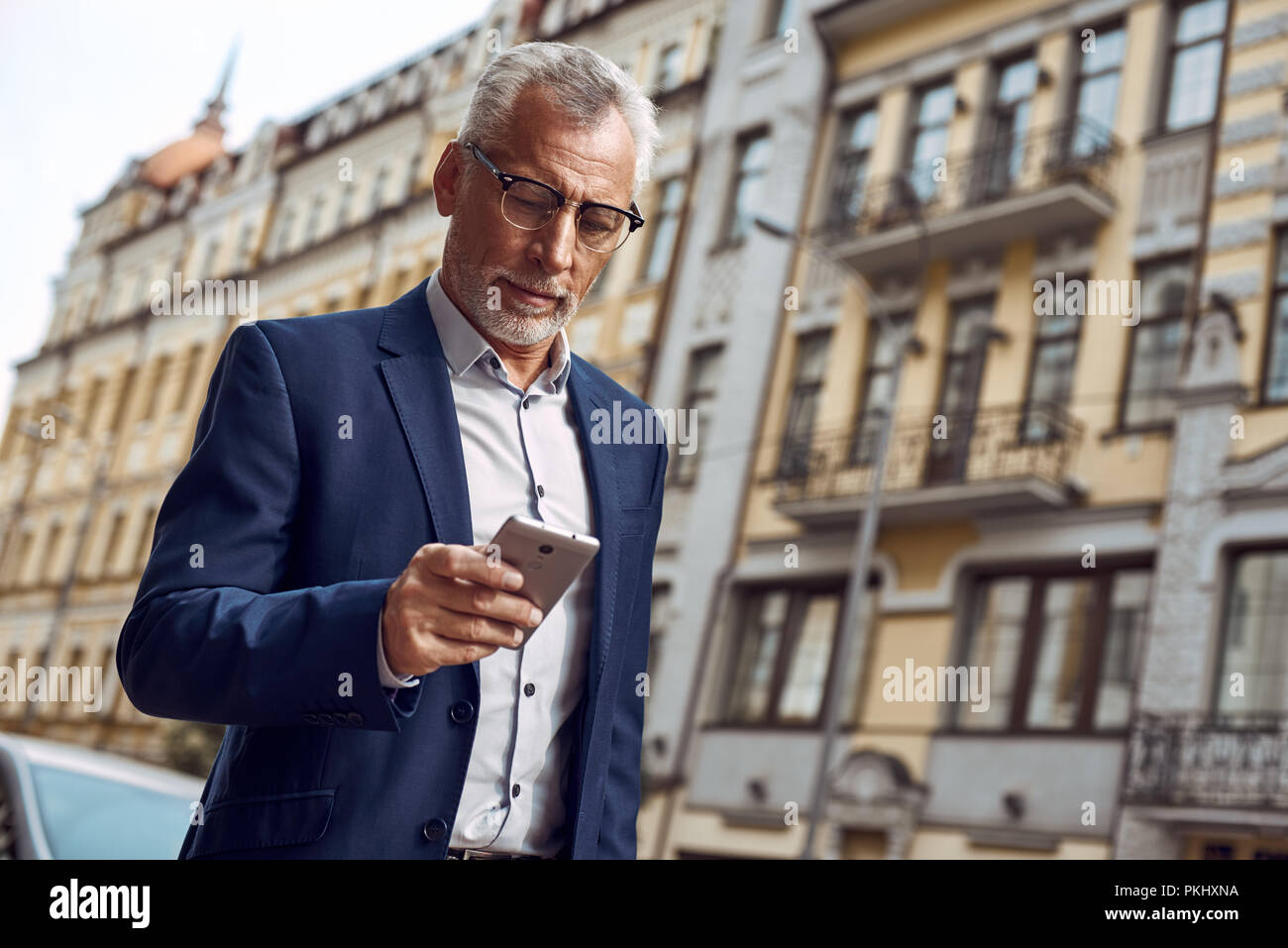 Business texting. Serious young businessman using mobile phone for work ...