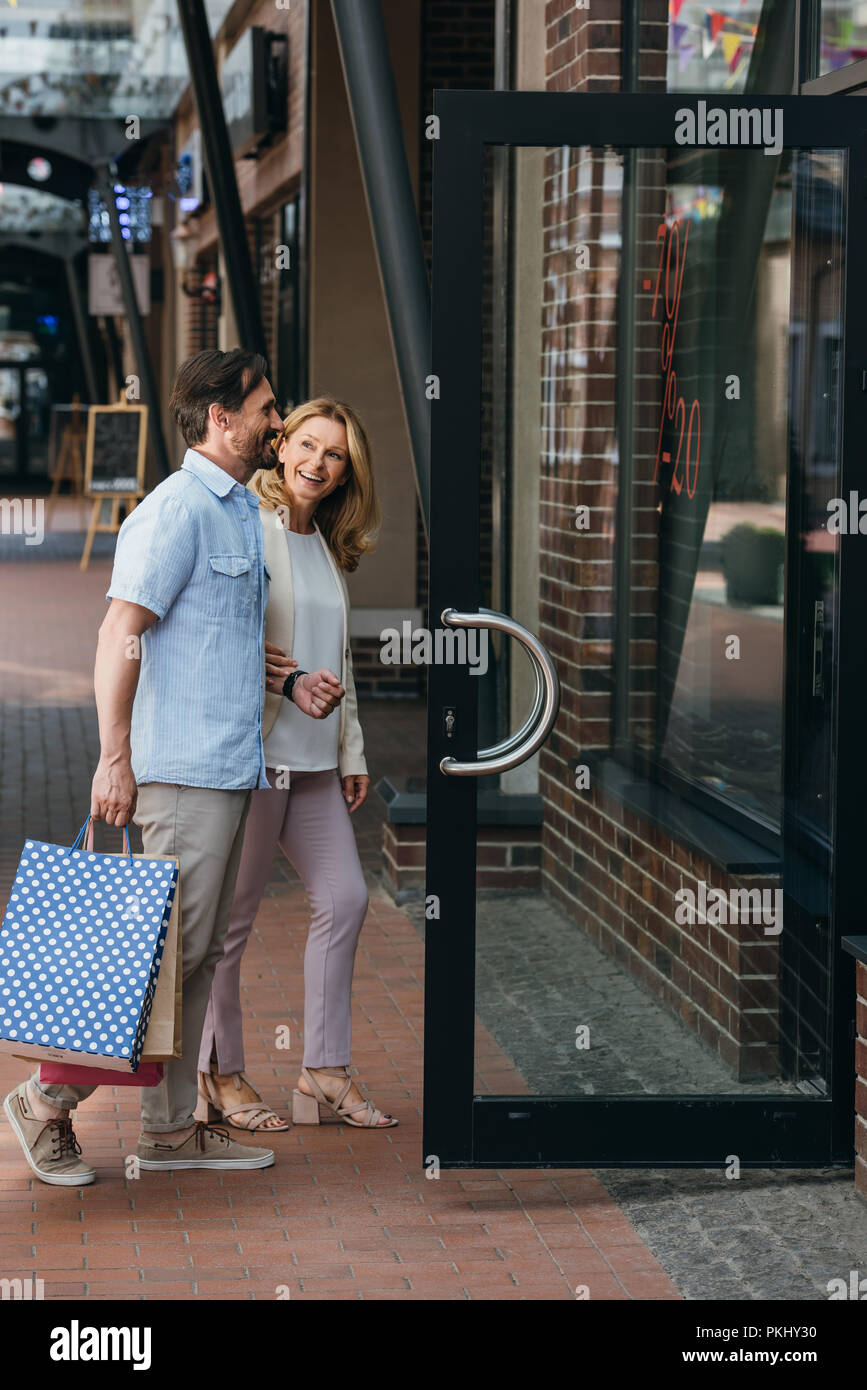 side view of couple entering shopping mall Stock Photo - Alamy