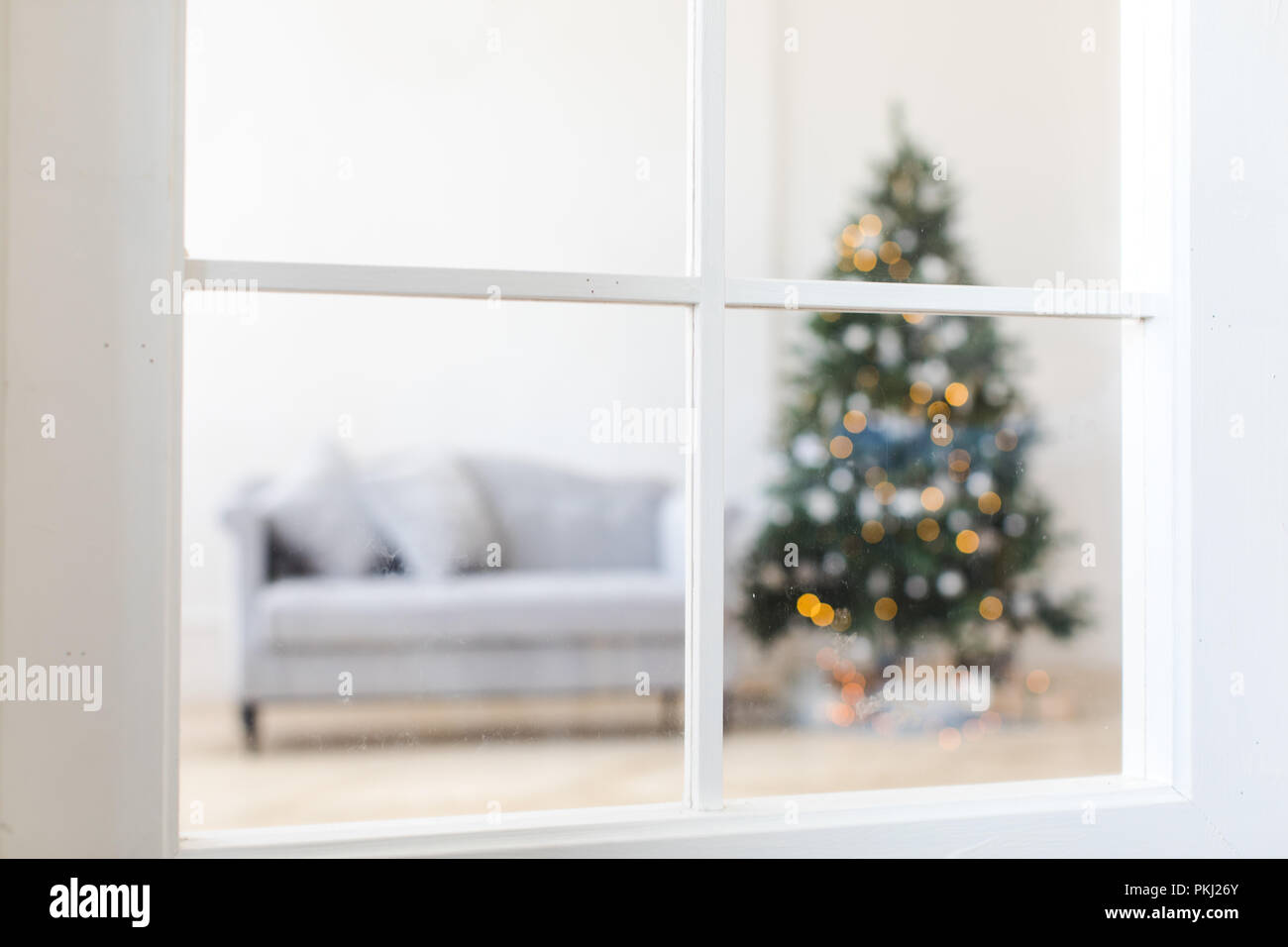Shining Christmas tree through window Stock Photo - Alamy